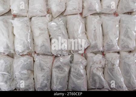 A large number of transparent sachets filled with white powder. White ...