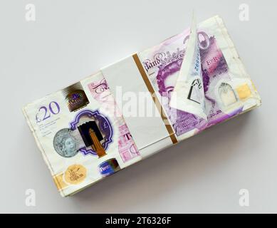 A bundled wad of british pound banknotes on an isolated light ...