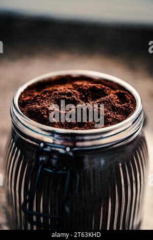 Top view of finely ground coffee filling a ribbed glass jar ...
