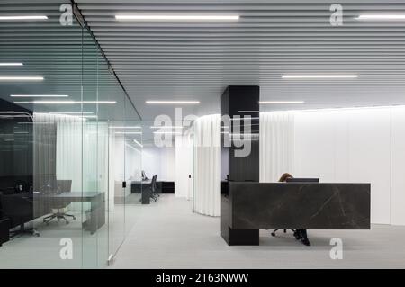 Reception desk of an office office with glass partitions and carpeted ...