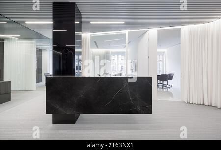 Reception desk of an office office with glass partitions and carpeted ...