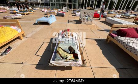 An art installation of "empty beds" and a "hostage table" in front of ...