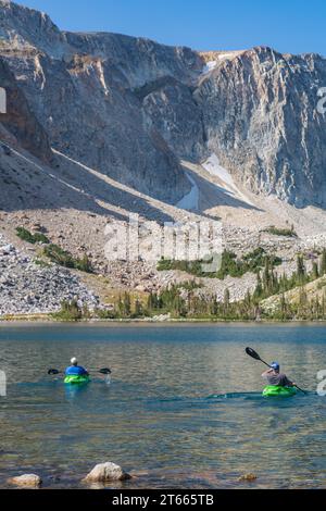 Two young men prepare for kayaking along the rock shoreline of Lake ...