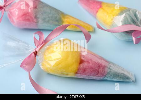 Packaged sweet light blue cotton candy hanging on clothesline against ...