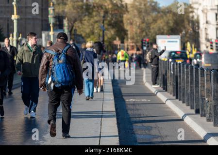 Pedestrians and cyclists crossing Westminster bridge towards Big Ben ...