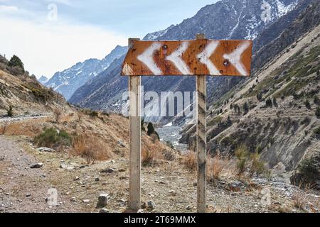 Dangerous driveway next to the cliff. Red road sign with white left ...