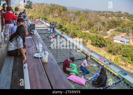 Customers eat, drink and relax on a net suspended over the hillside at ...