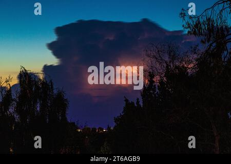 Intra cloud lightning in a thunderhead cumulonimbus cloud at dusk over ...