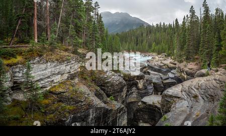 A tourist takes a photo of Mistaya Canyon in Banff National Park ...