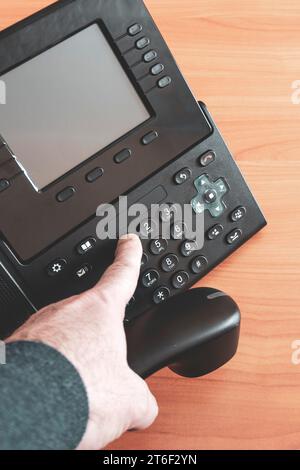 The hand holds a phone tube. Close-up. Dialing a number with your hand ...