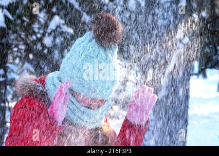 Blurred photo. Girl snowfall on the background of the forest. A child ...