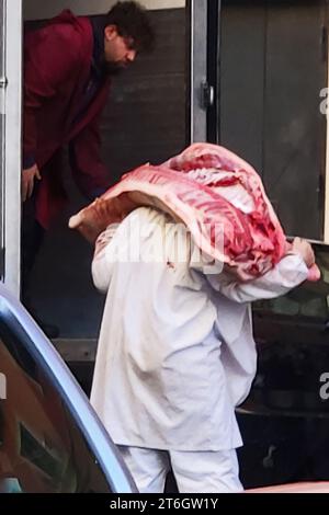 Meat arrives in the city center for the butcher shop, Two men unload ...