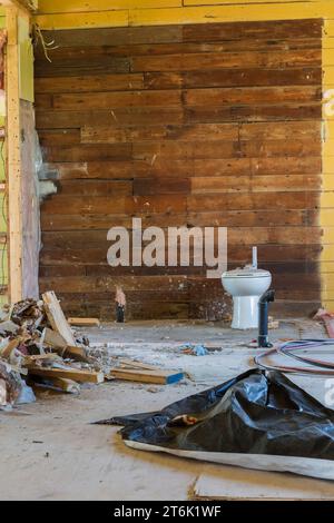 Old toilet with water tank removed and debris in abandoned commercial ...