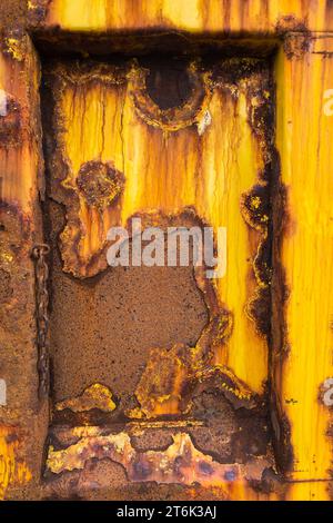 Rust spots and stains on side wall of old yellow metal waste container ...