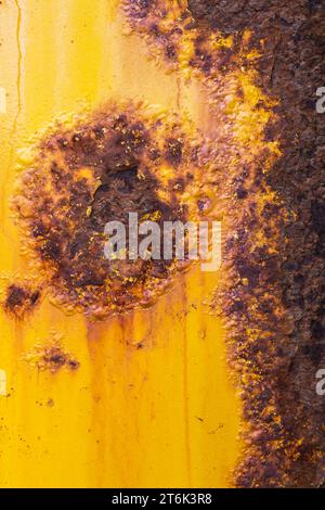 Rust spots and stains on side wall of old yellow metal waste container ...