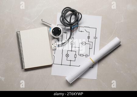 Wiring diagram, wires, tape measure and notepad on light table, flat ...