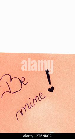 Be mine handwriting text close up isolated on orange paper with copy ...