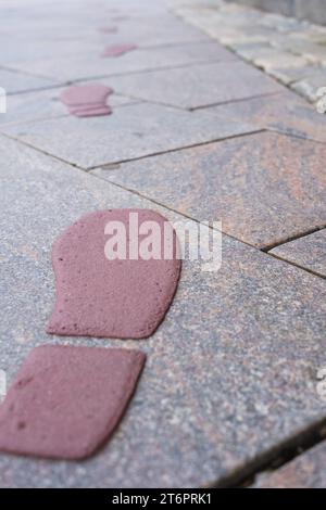 Footprint marks on the ground, painted to mark a tourist route in a ...