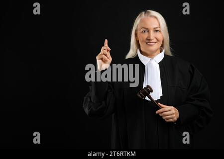 Judge with gavel pointing at something on light brown background. Space ...