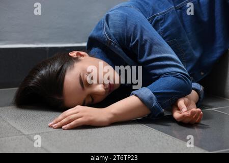 Unconscious woman lying on floor after falling down stairs indoors ...