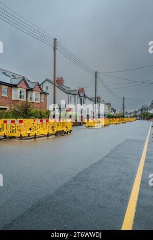 Pipe laying roadworks in Cardiff. Bright yellow safety barriers protect ...