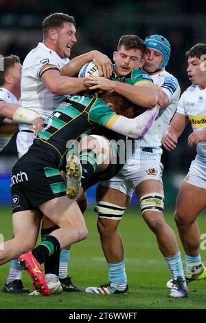 Ross Vintcent of Exeter Chiefs is tackled by Jeremy Loughman and John ...