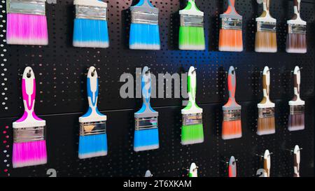 Multi-colored brushes for repairing black wall painting hang on a stand ...