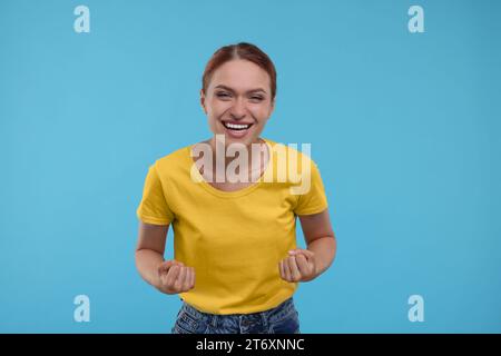 Happy fan celebrating on light blue background Stock Photo - Alamy