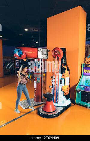 Woman playing arcade game Stock Photo - Alamy