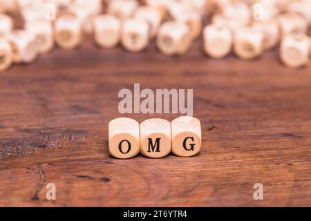 OMG written on a wooden cubes on soft pink background for Oh Mine God ...