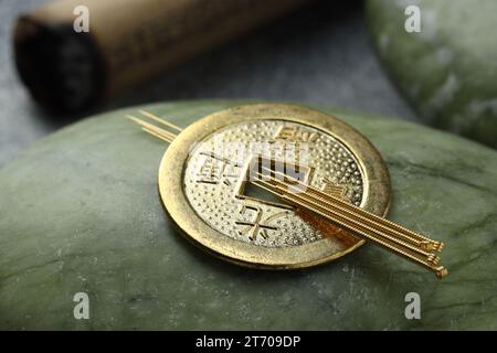 Acupuncture needles and ancient coin on grey textured table, closeup ...