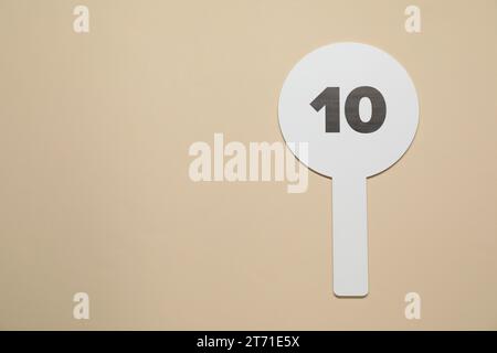 Auction paddle with number 2 on beige background, top view. Space for ...