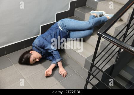 Unconscious woman lying on floor after falling down stairs indoors ...