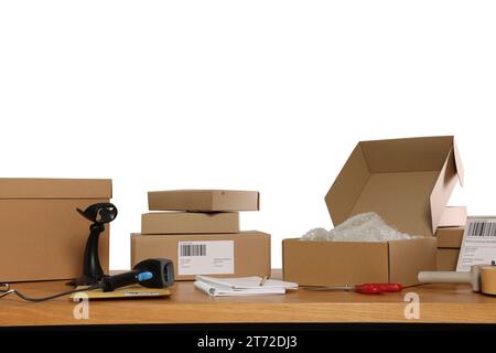 Parcels, barcode scanner and stationary on wooden table against white ...