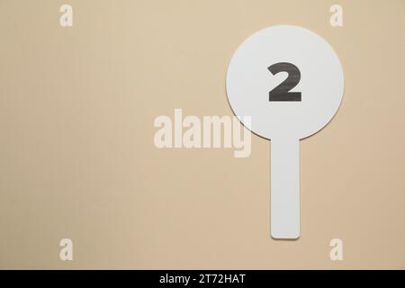 Auction paddle with number 3 on beige background, top view. Space for ...