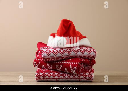 Stack of sweaters and hat on color background Stock Photo - Alamy