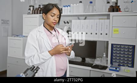 Young pregnant woman working at scientist laboratory smiling with happy ...