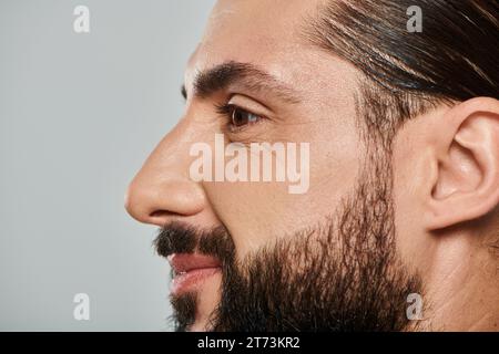 profile of cheerful arabic man with beard smiling and looking away on ...