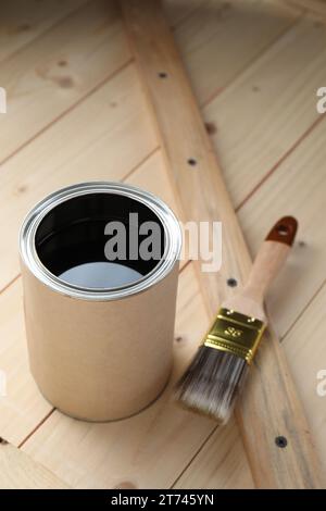Can and brush with wood stain on wooden surface Stock Photo - Alamy