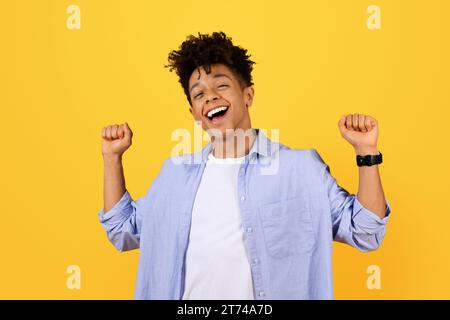 Jubilant Young Man Celebrating Success With Raised Fists Stock Photo ...