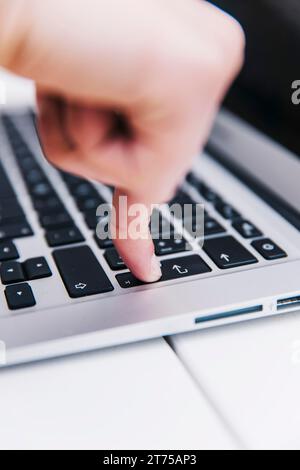 Man pressing the letter F key on a simple laptop computer keyboard ...