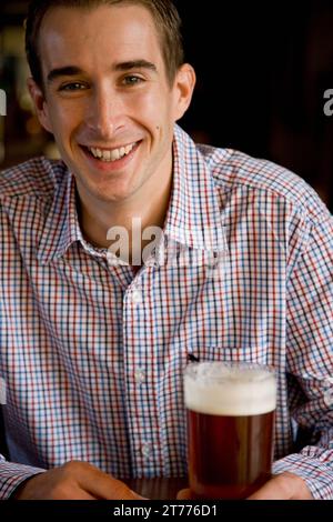 A person drinking a pint of beer at a Young & Co's Brewery Stock Photo ...