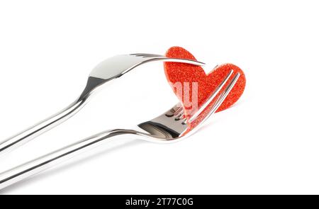 decorative red heart near forks on white background with space for text ...
