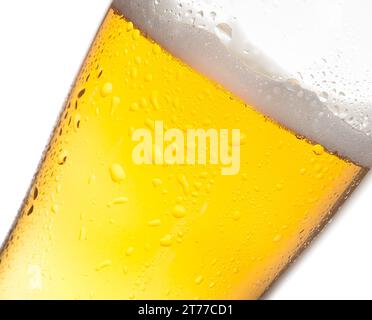 tilted glass of fresh beer with drops on white background, with space ...