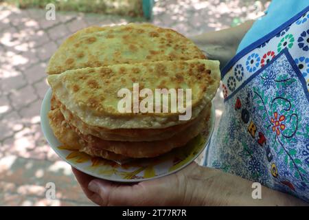 Grandmother holding a full plate of pasties in her hands, traditional ...
