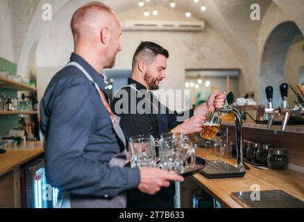 Two men friends barman and waiter with tray dressed black uniform at ...