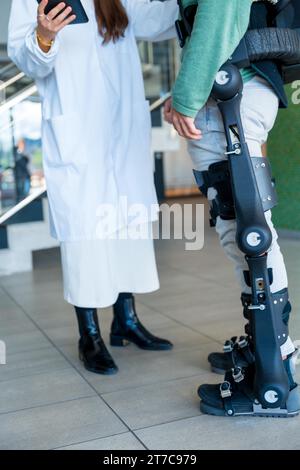Mechanical exoskeleton. Physiotherapy smiling in modern hospital ...