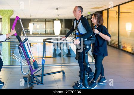 Mechanical exoskeleton. Female physiotherapy doctor assistant lifting ...