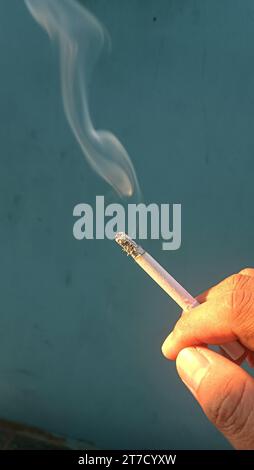 Finger holds a lit cigarette Stock Photo - Alamy