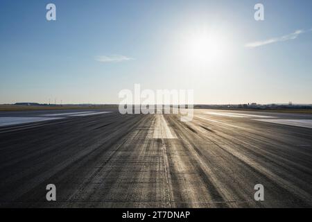 Surface level of long airport runway with directional marking against ...